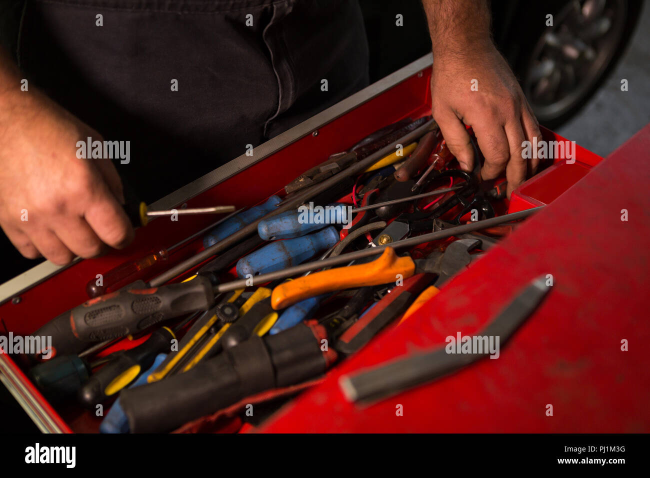 Male mechanic removing tools from drawer Stock Photo - Alamy