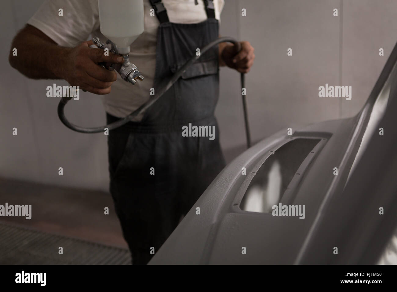 Male mechanic using spray paint Stock Photo - Alamy