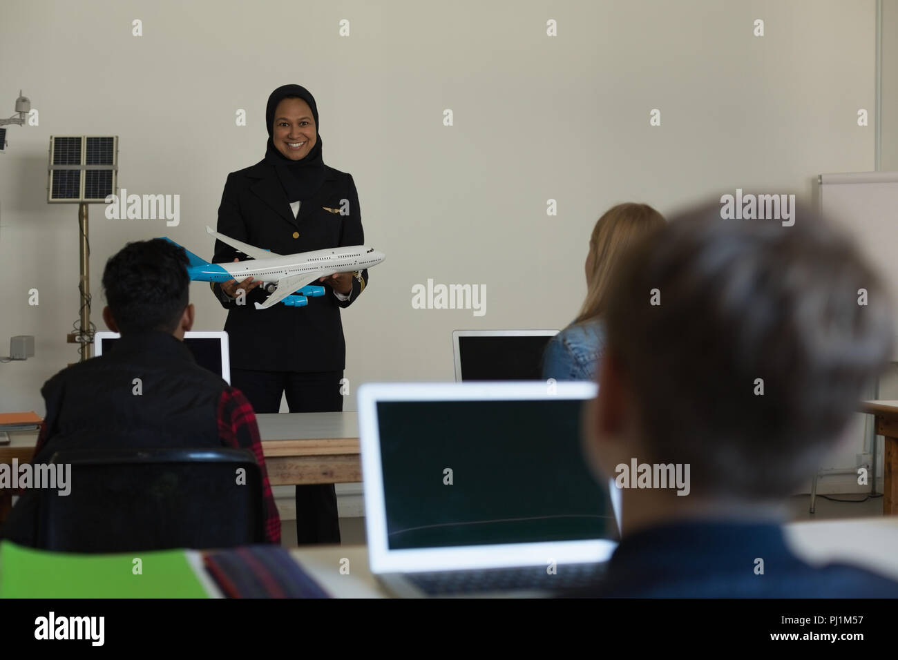 Female pilot teaching about model plane to kids Stock Photo - Alamy