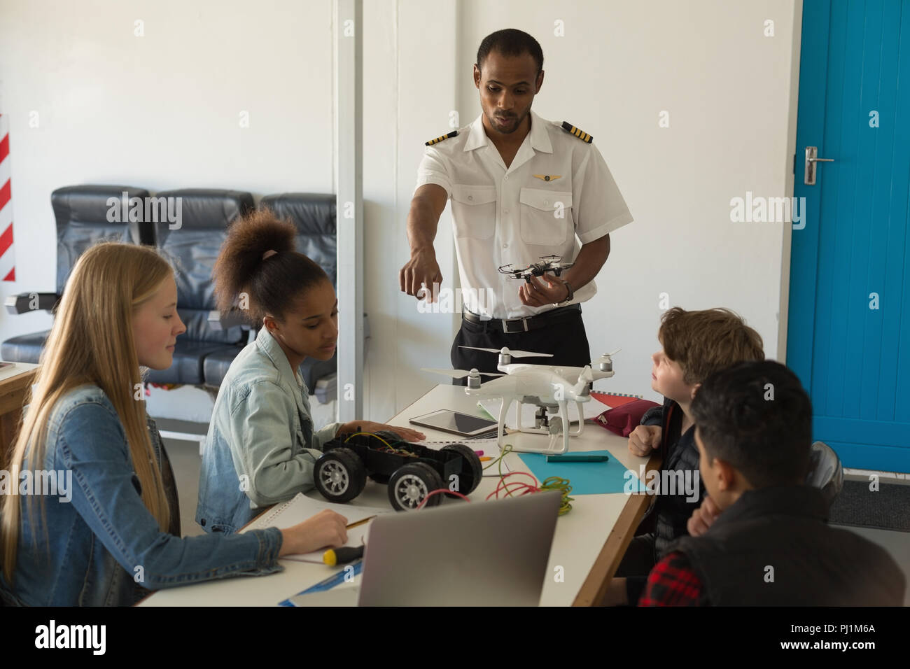 Pilot giving training about model aeroplane to students Stock Photo - Alamy