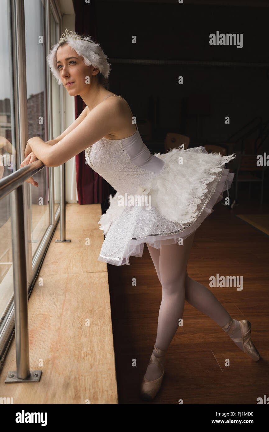 Ballerina looking through window in dance studio Stock Photo - Alamy