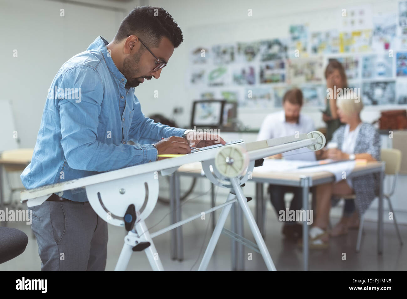Male executive working over drafting table Stock Photo - Alamy