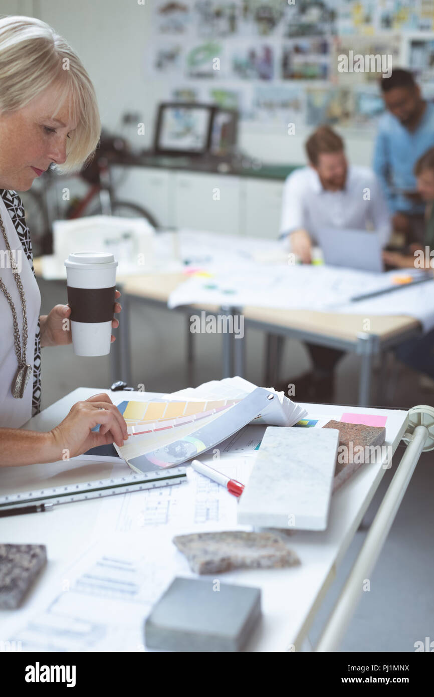 Female executive checking color swatch on drafting table Stock Photo ...