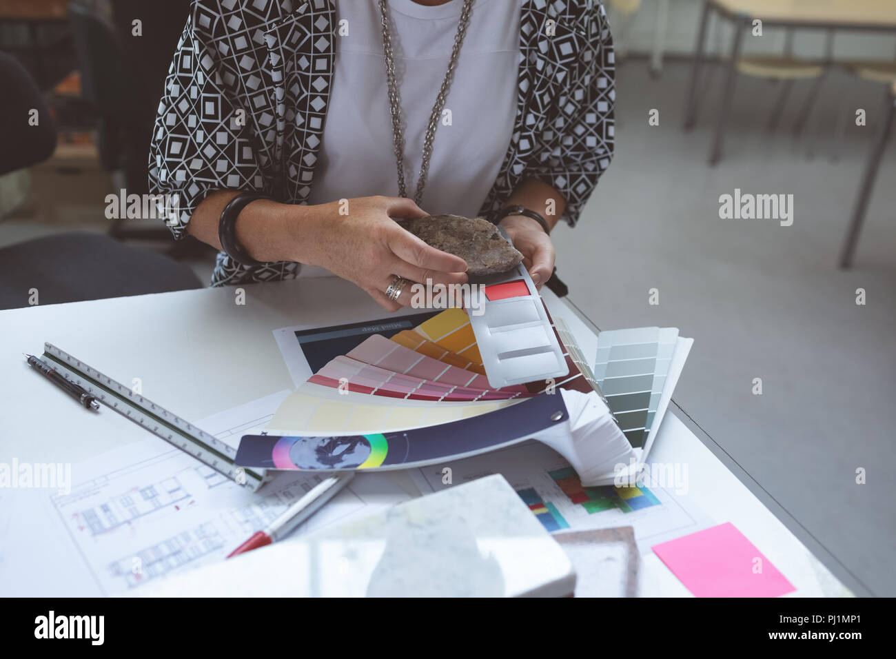 Female executive checking color swatch on drafting table Stock Photo ...