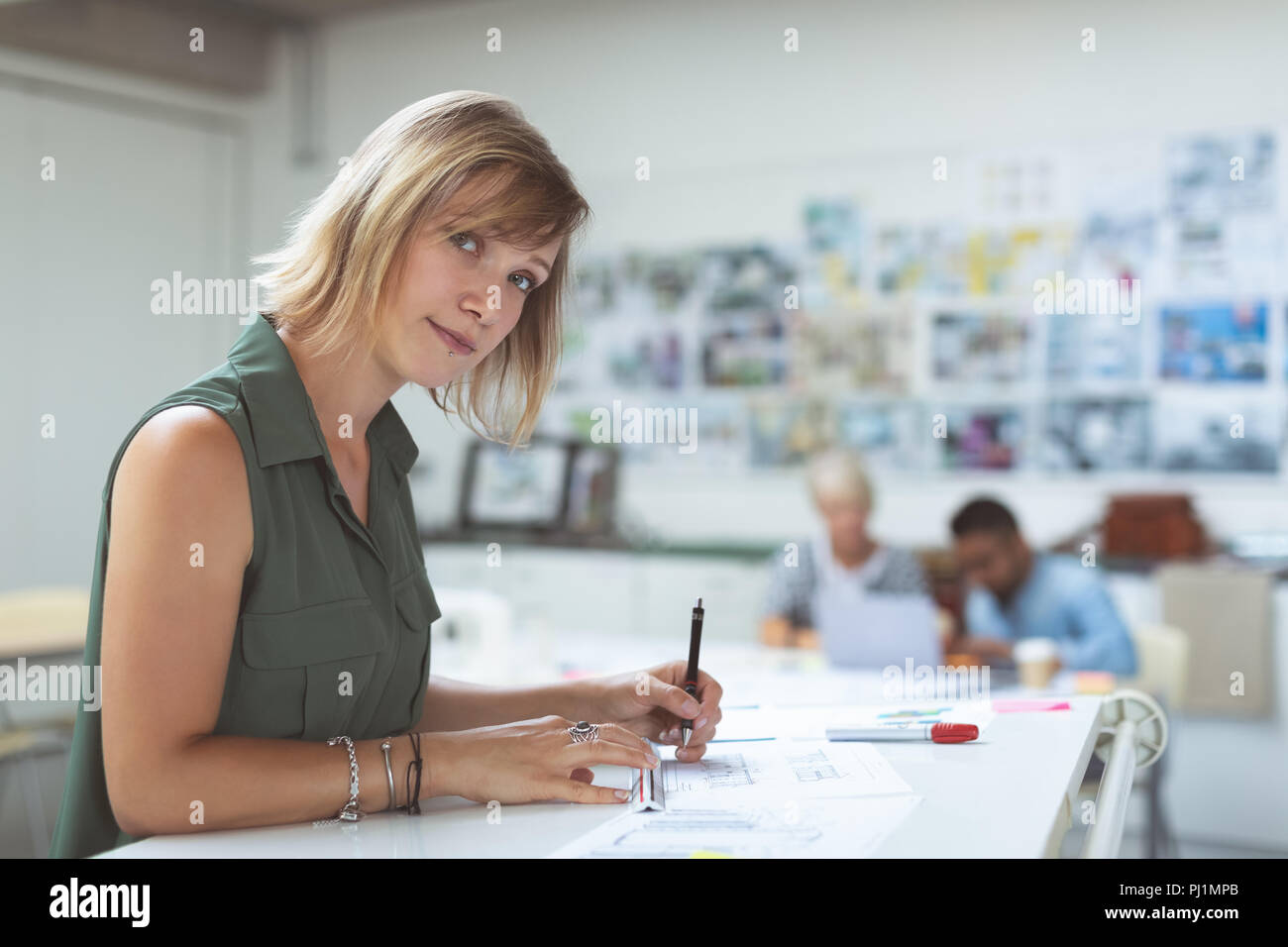 Female executive working on drafting table in office Stock Photo - Alamy
