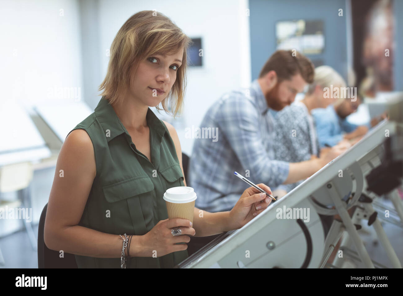 Female executive working on drafting table in office Stock Photo - Alamy