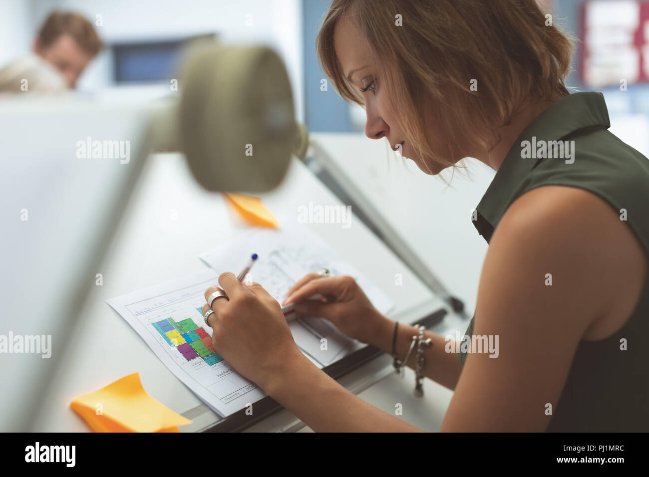 Female executive working on drafting table Stock Photo - Alamy