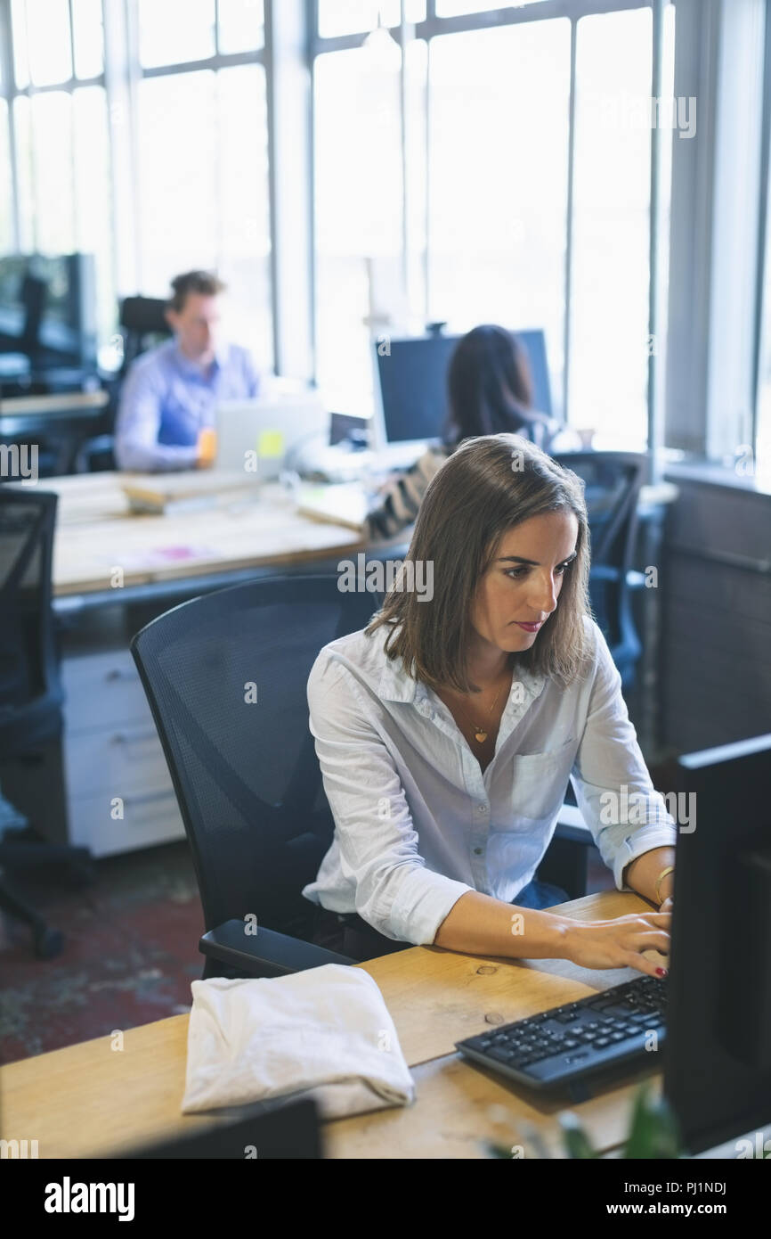 Female executive working on computer at desk Stock Photo - Alamy