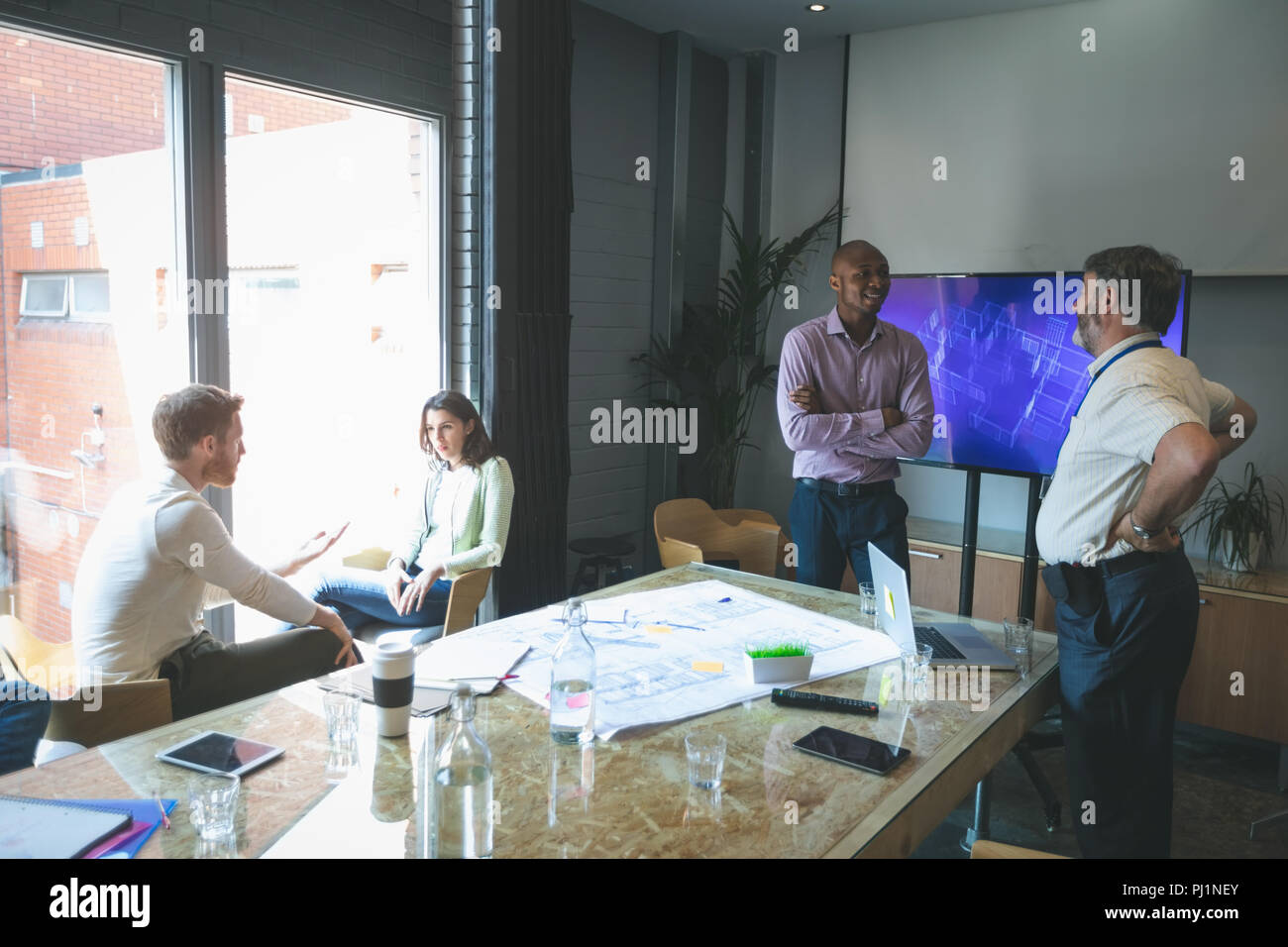 Business people interacting with each other in the conference room ...