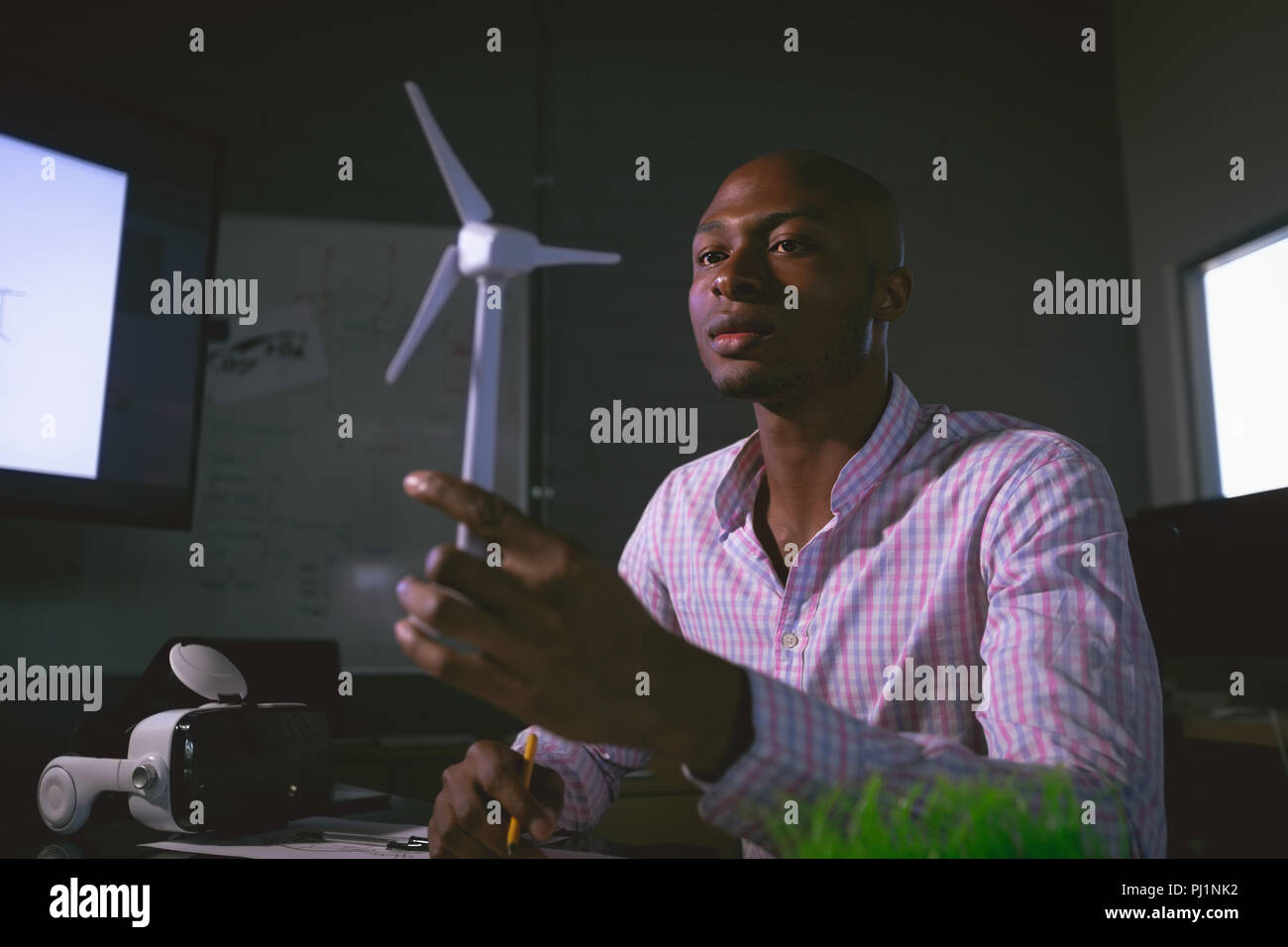Male executive examining a windmill model Stock Photo - Alamy
