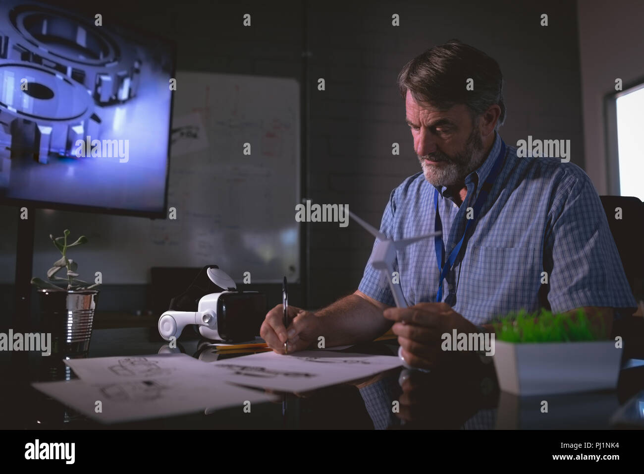 Male executive examining a windmill model Stock Photo - Alamy