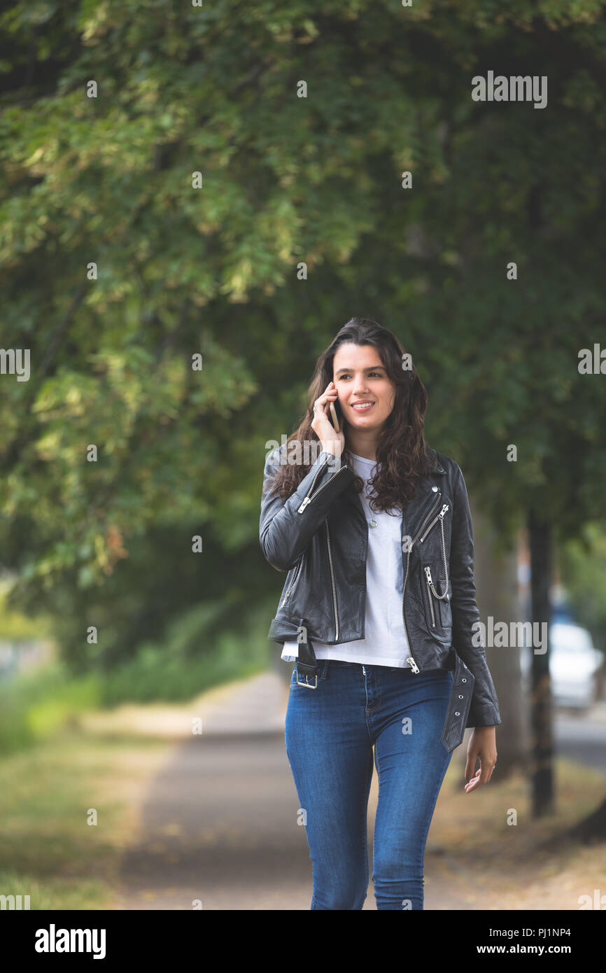 Woman walking on street talking hi-res stock photography and images - Alamy