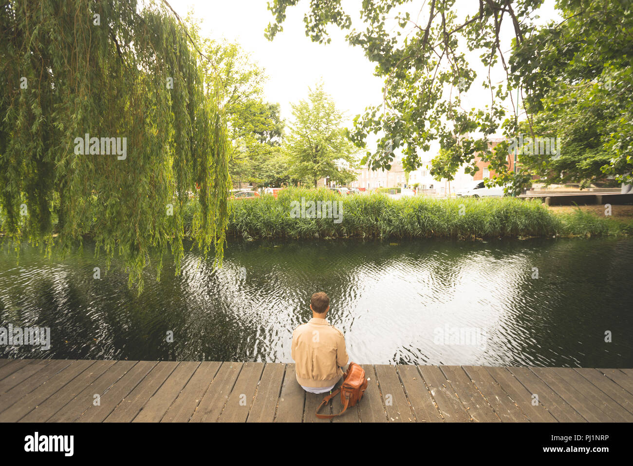 Man sitting by lake hi-res stock photography and images - Alamy