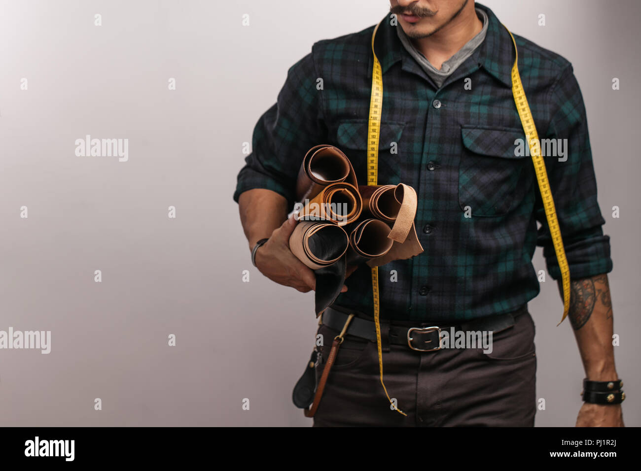 Artisan of leather in creative black hat posing with leather goods in ...
