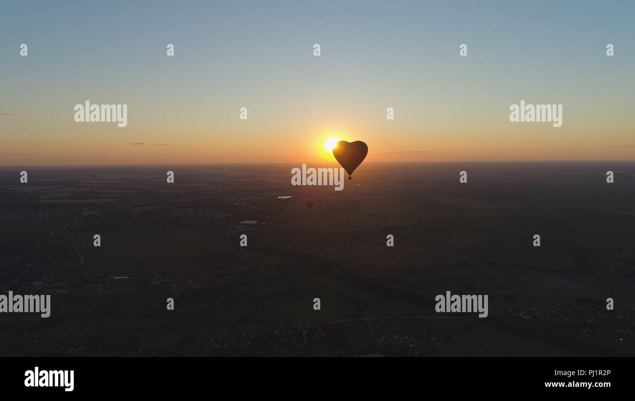 Aerial view Hot air balloon shape heart in sky over field in ...