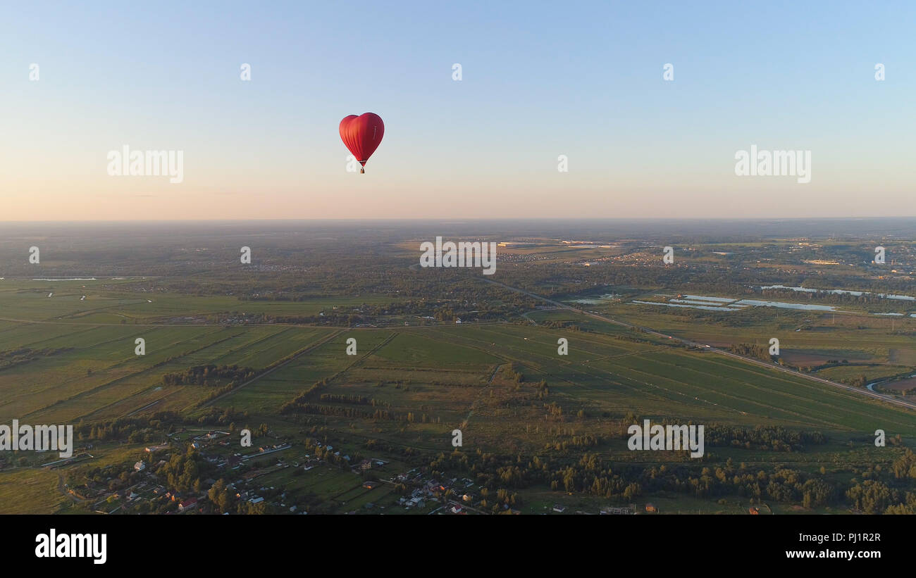 Aerial view Hot air balloon shape heart in sky over field in ...
