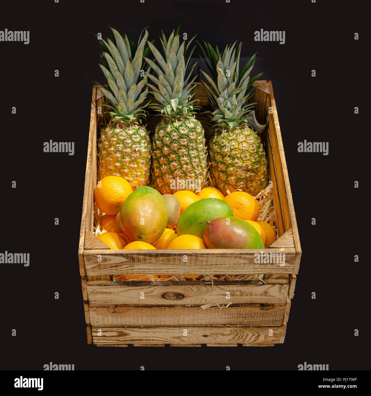 wooden box with tropical fruits separated on black Stock Photo - Alamy