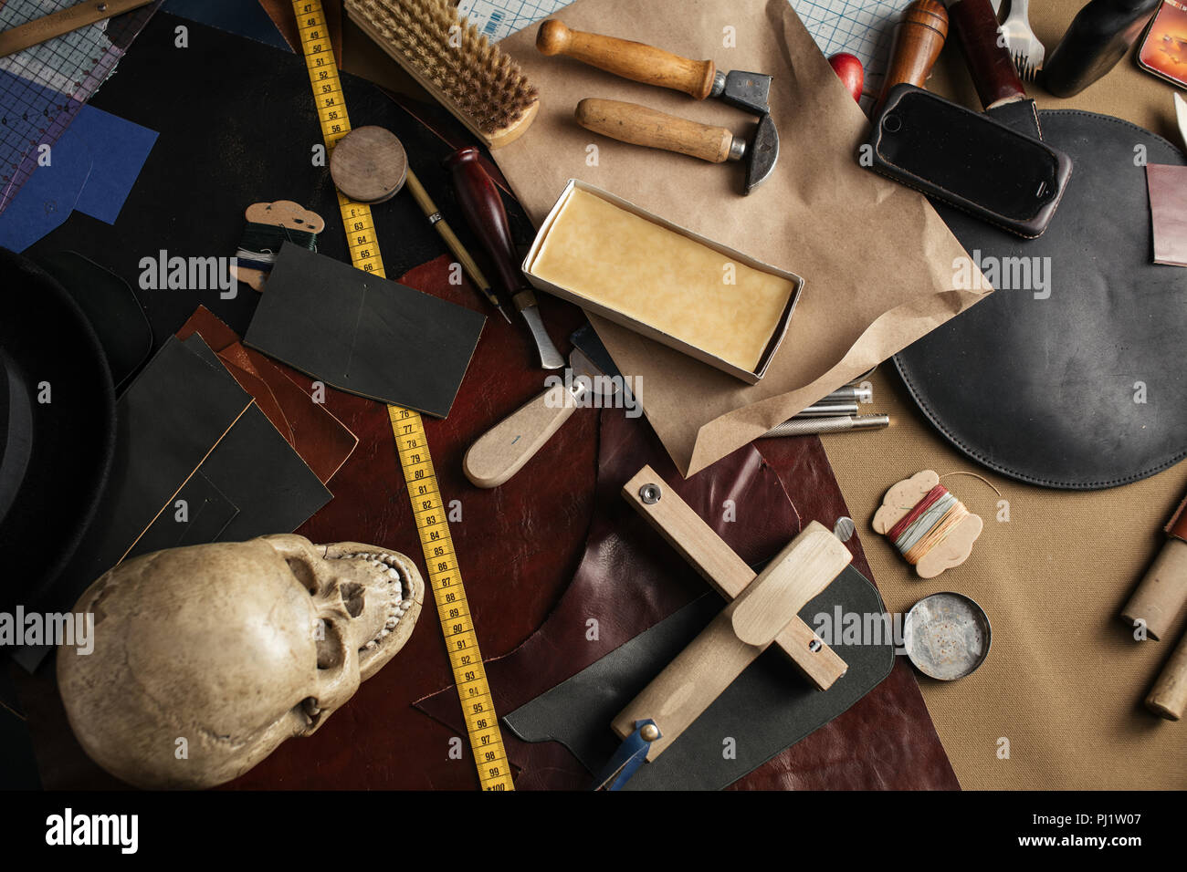 Set of leather craft tools on paper background. Workplace for shoemaker ...
