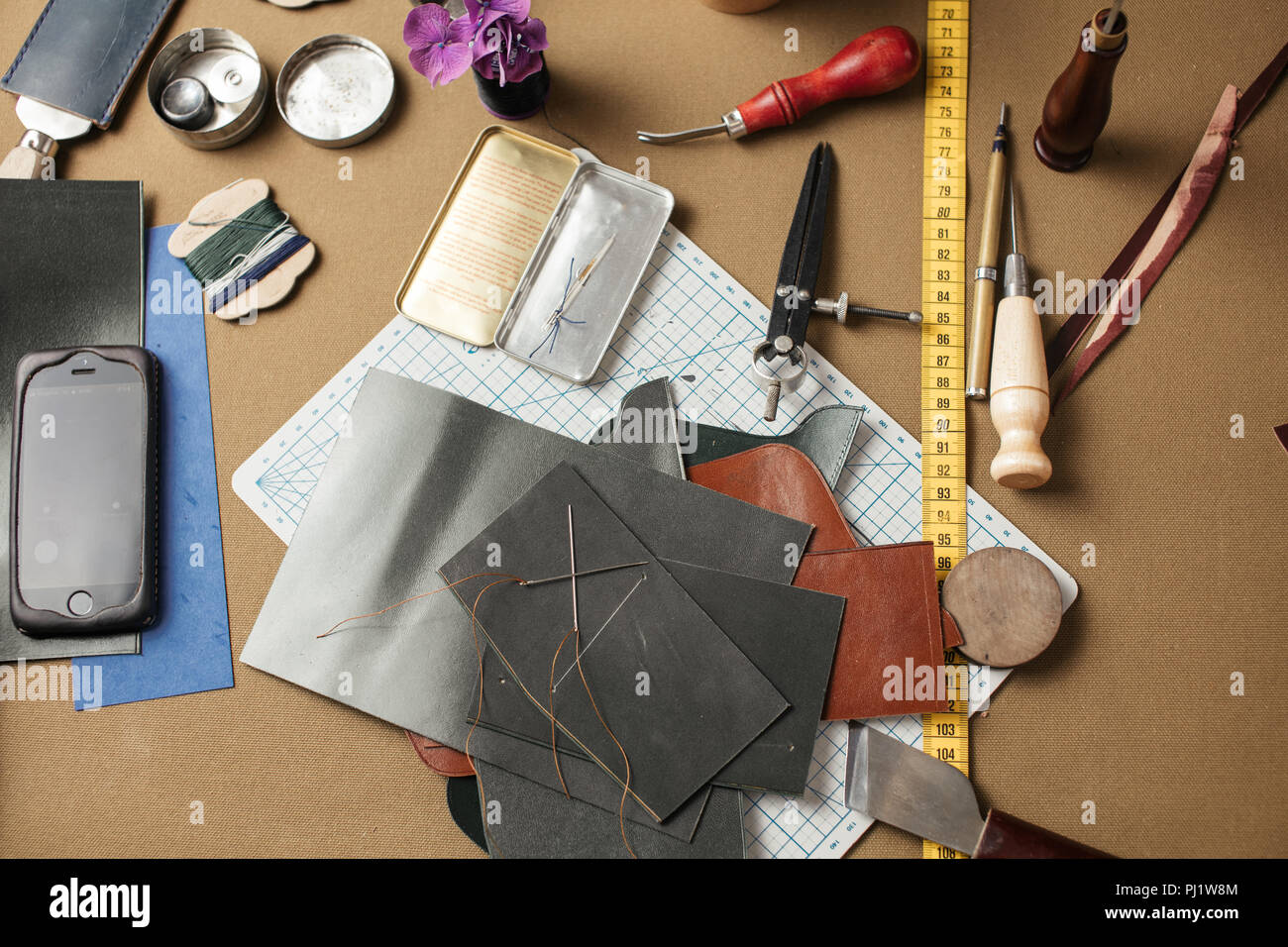 Set of leather craft tools on paper background. Workplace for shoemaker ...
