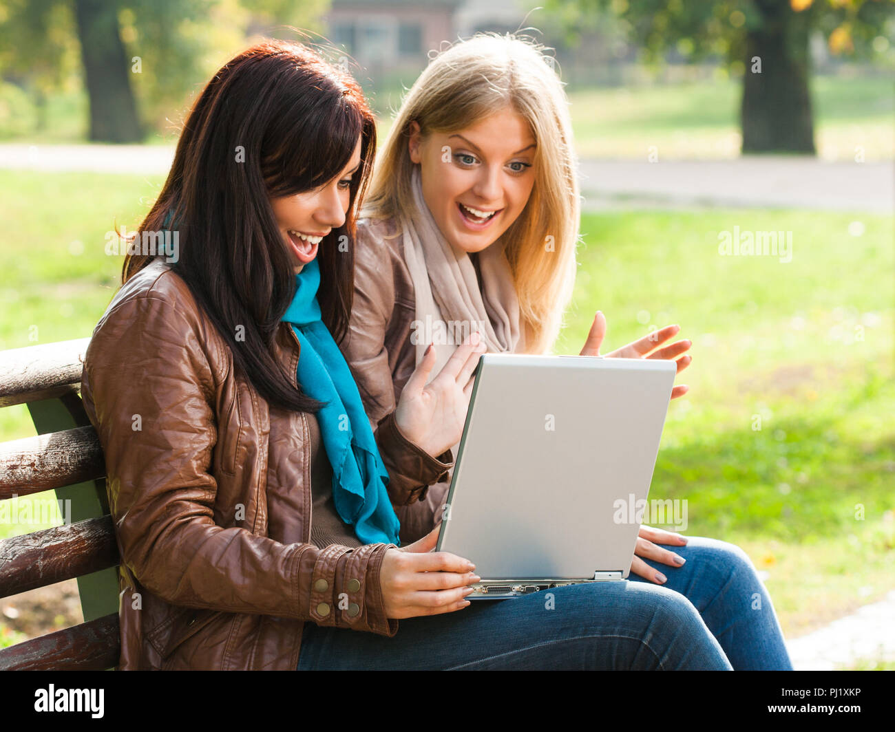 Young girls using laptop outdoor Stock Photo - Alamy