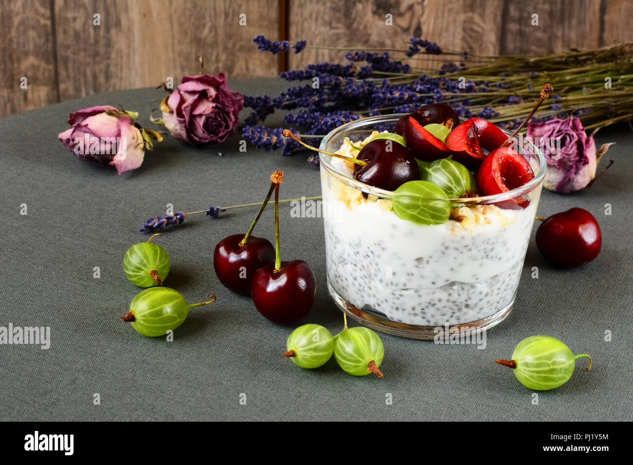 Yogurt with seeds a chia and berries on grey background Stock Photo - Alamy