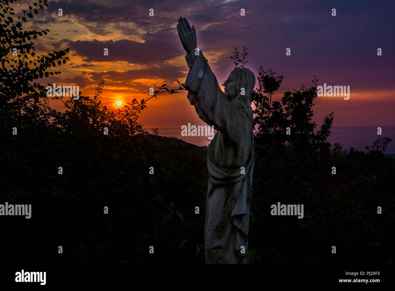 Jesus statue at a beautiful sunset at Corfu - Greece Stock Photo - Alamy