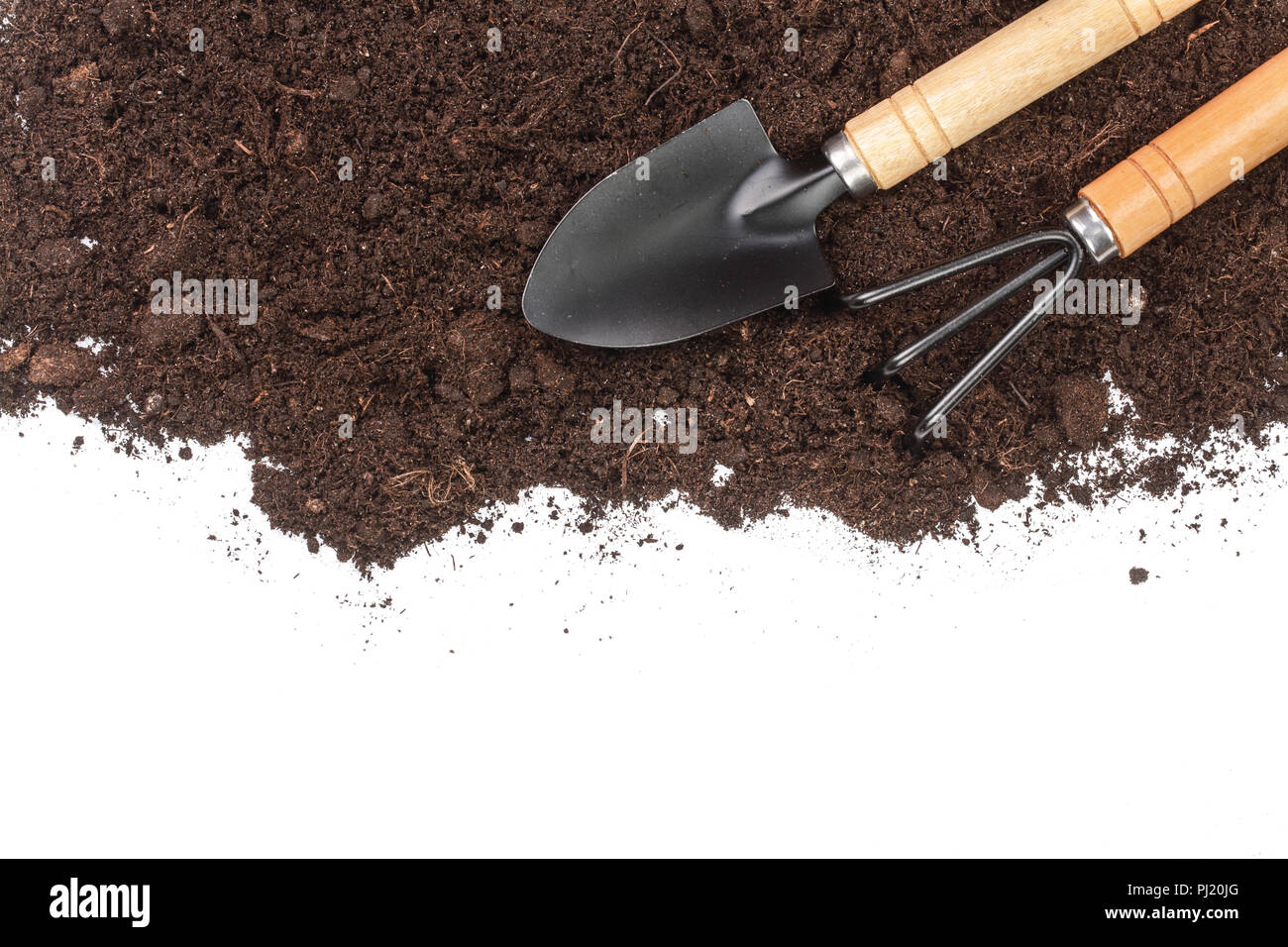 garden tools in soil isolated on white background with copy space for ...