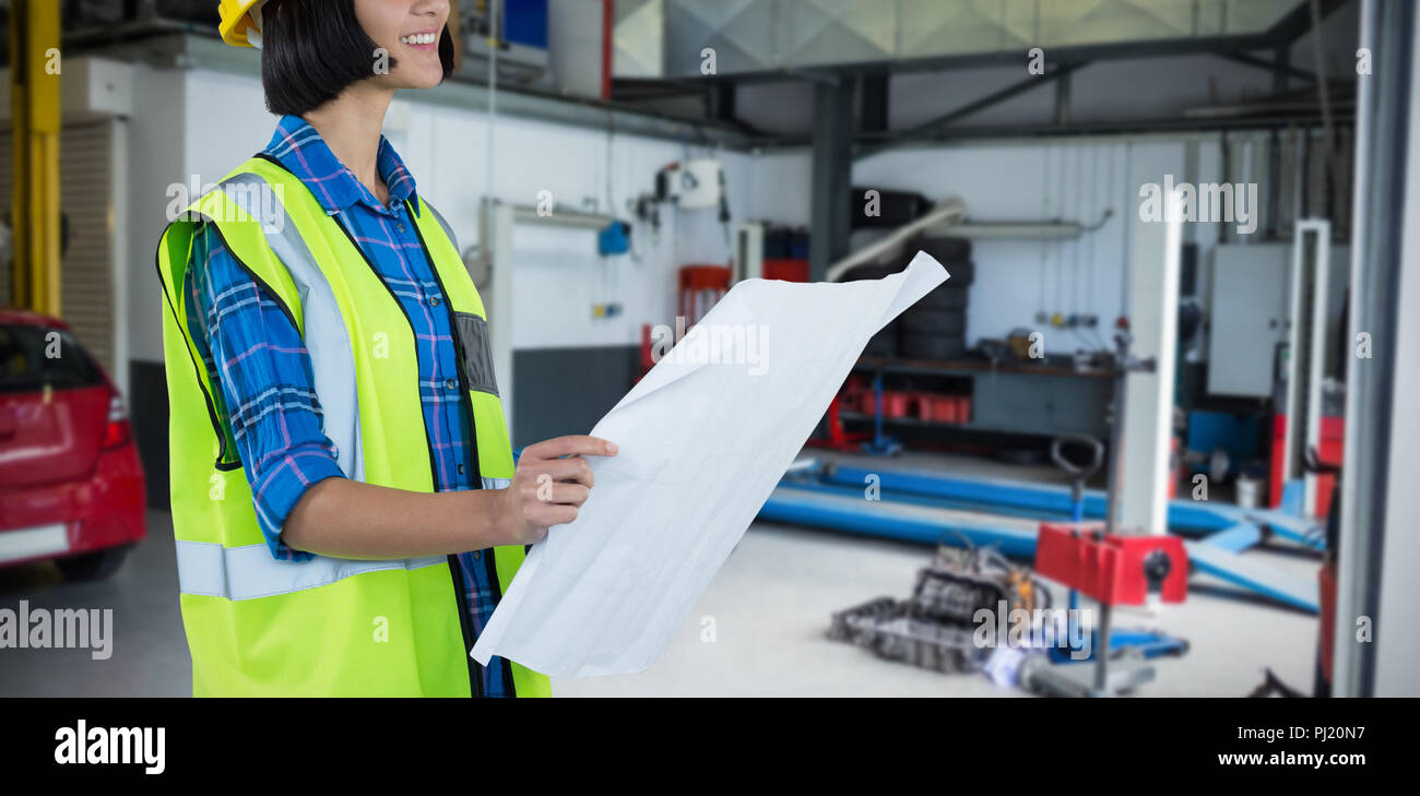 Composite image of female architect looking at blueprint against grey ...