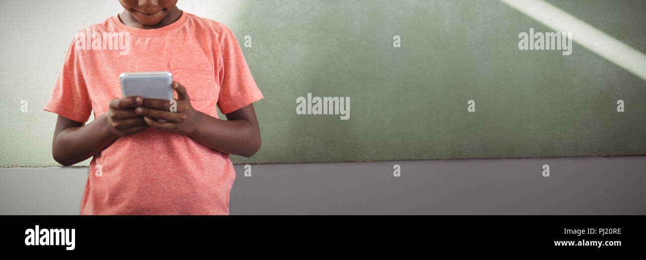 Boy using cellphone against greenboard in school Stock Photo - Alamy