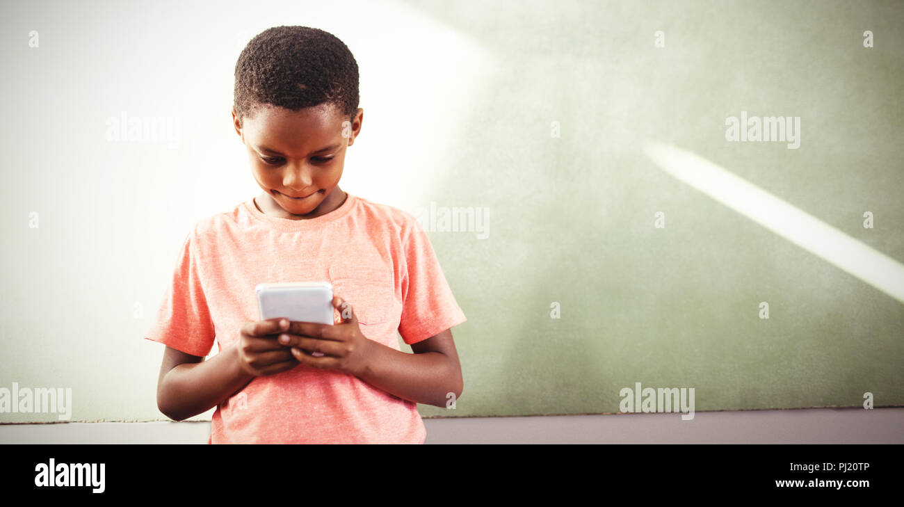Boy using cellphone against greenboard in school Stock Photo - Alamy