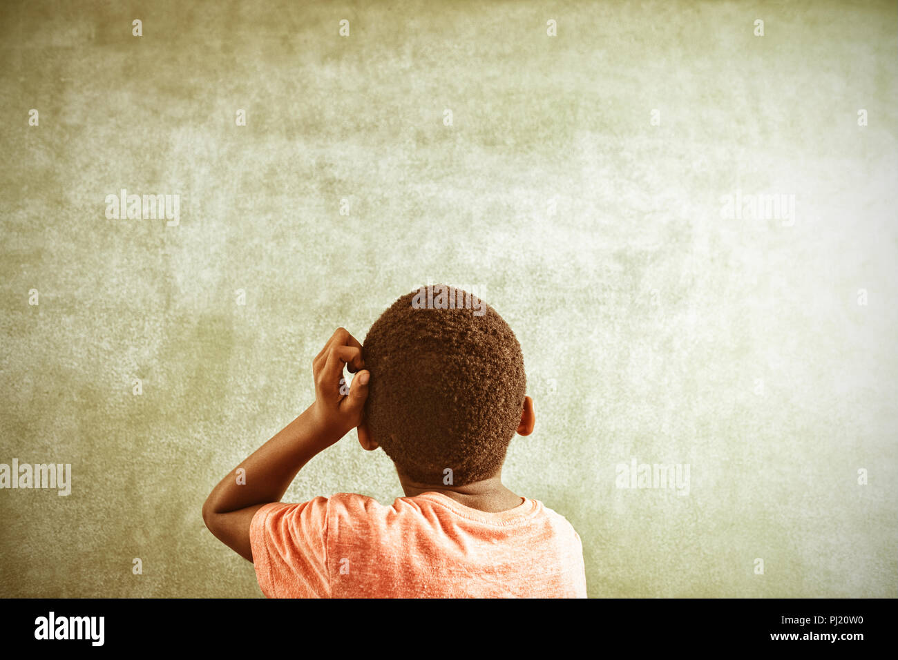 Rear view of thoughtful boy against greenboard Stock Photo - Alamy