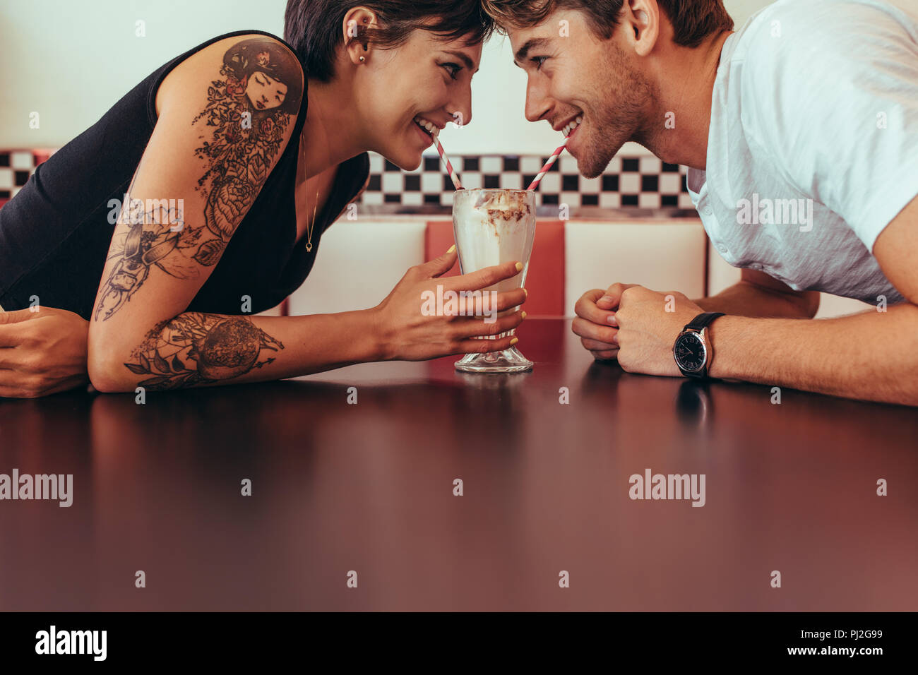 Young couple sharing milkshake hi-res stock photography and images - Alamy