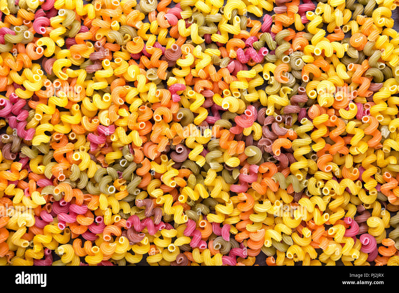 a scattered colored pasta, not cooked, background for recipe Stock ...