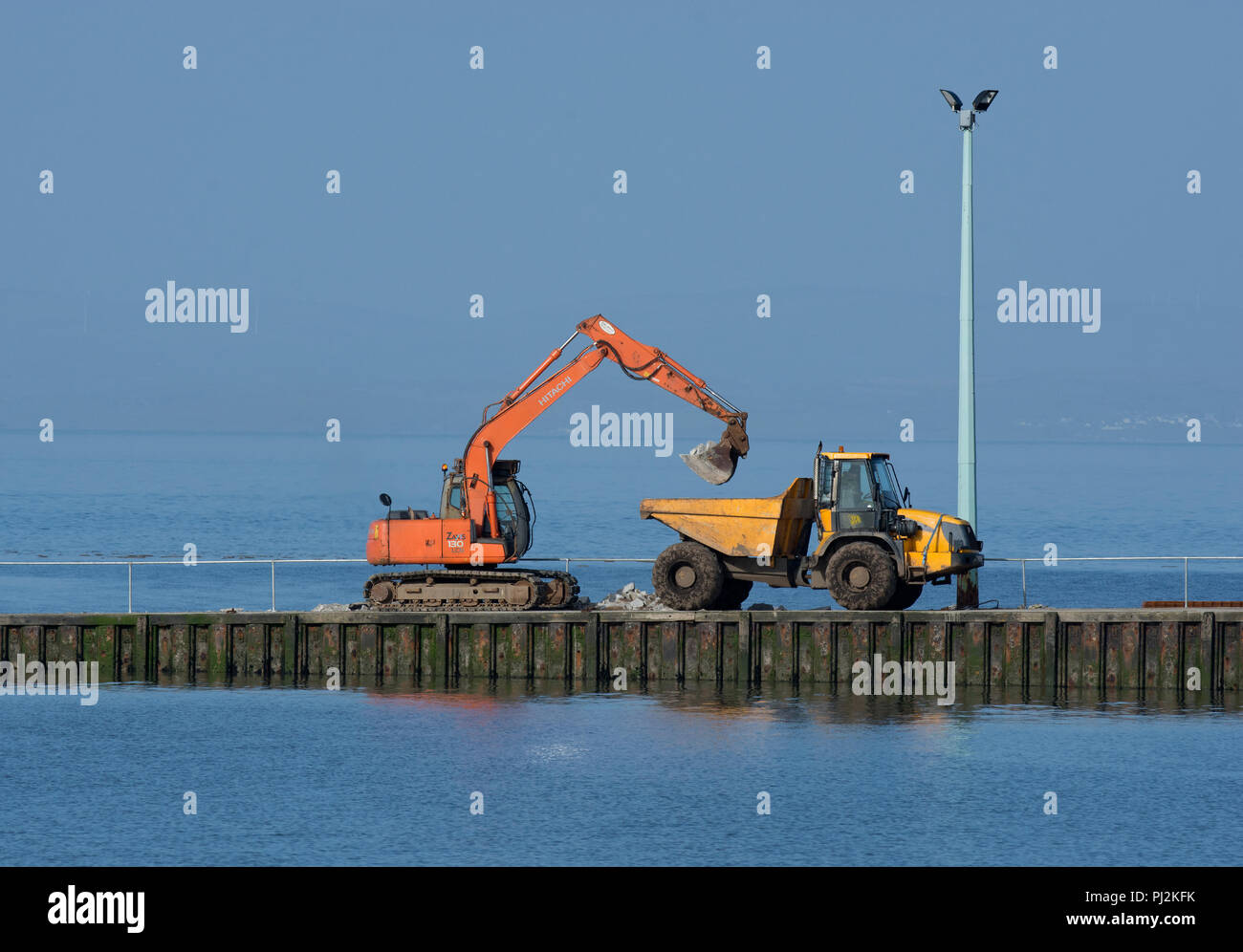 Construction digger with dumper truck on ferry slipway, Knott End on ...