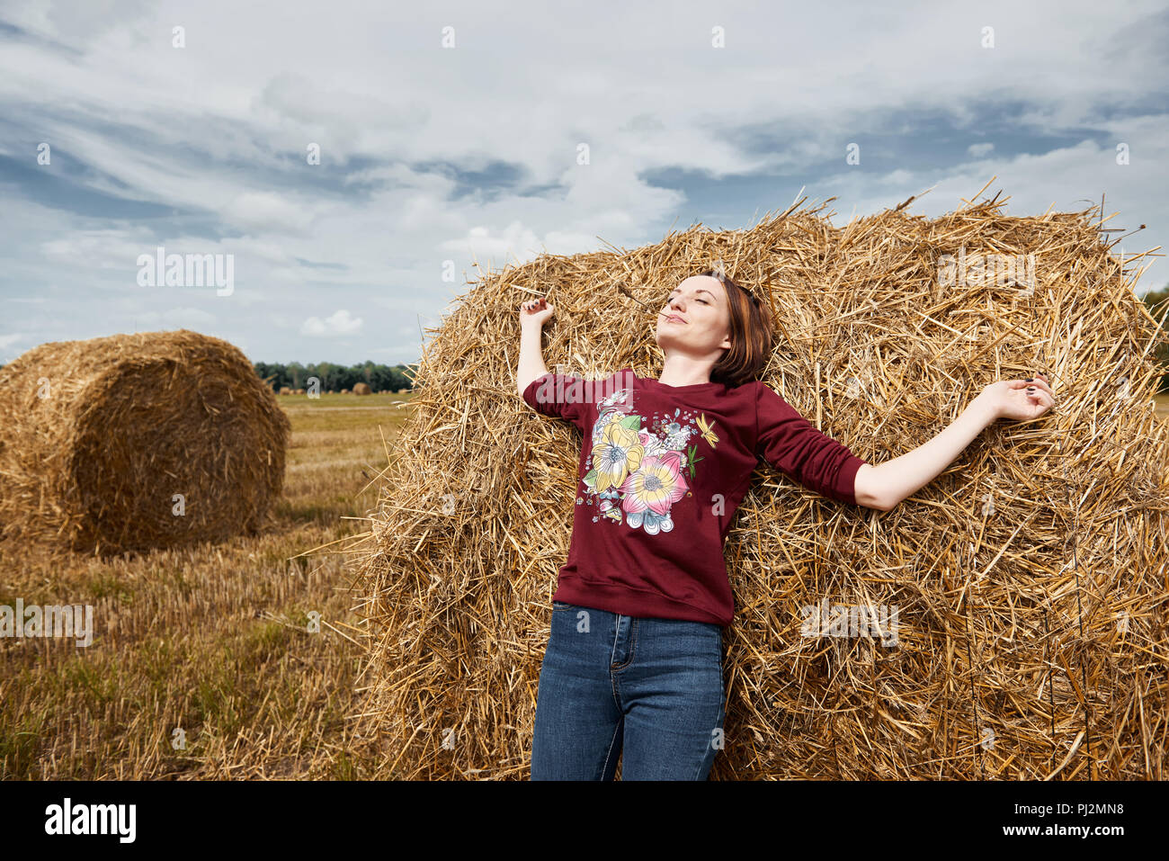 young girl having fun in the field, lying on a haystack Stock Photo - Alamy