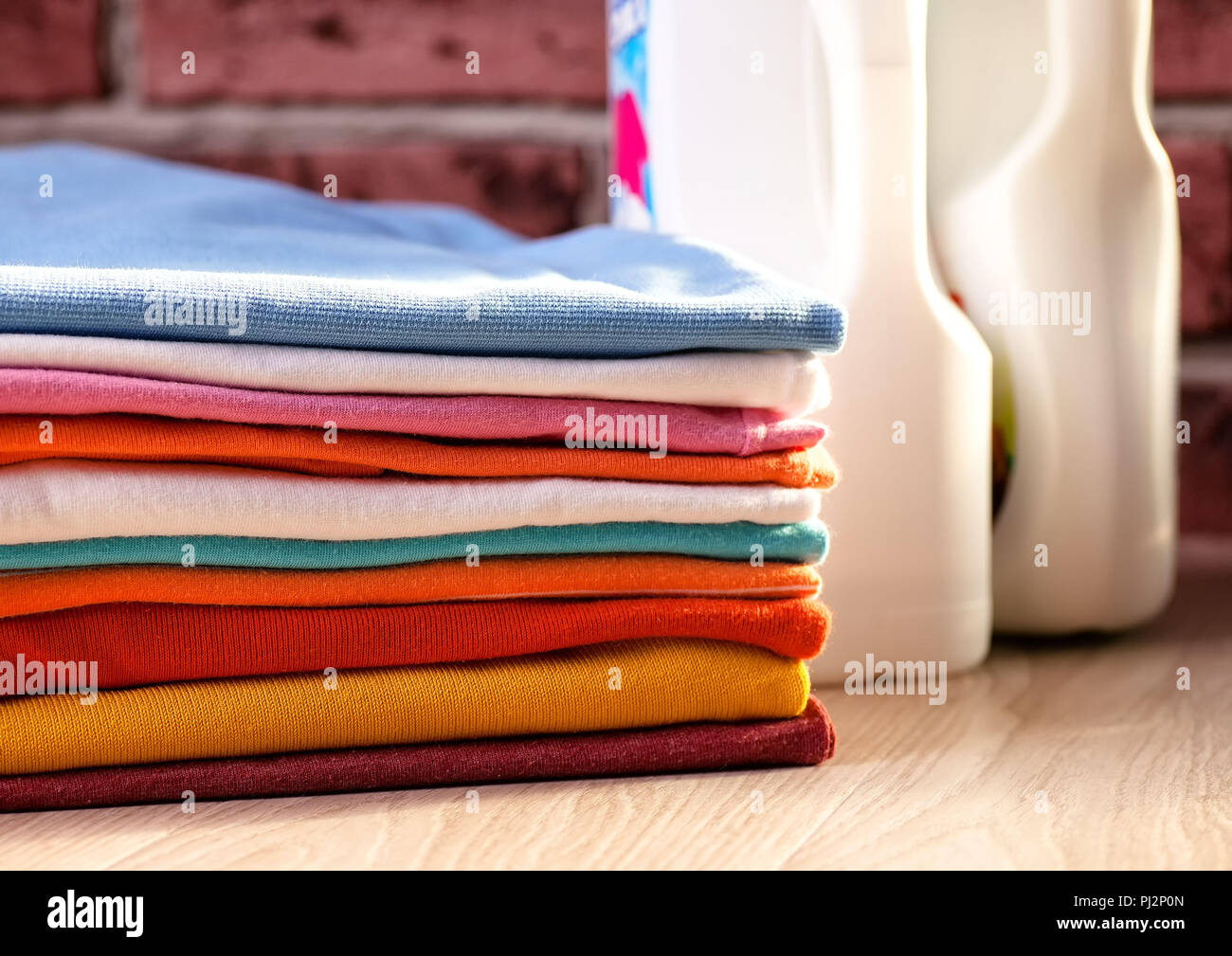 Clean, colorful, folded clothes. Means for washing clothes Stock Photo ...