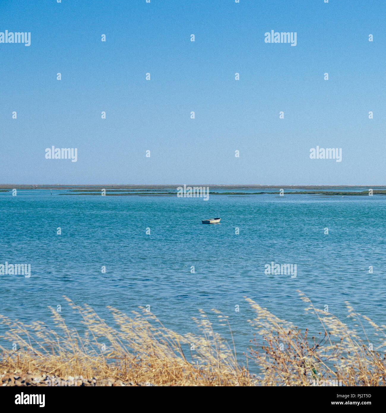 Beautiful minimalist scenery of wooden fishing boat on middle of lake ...