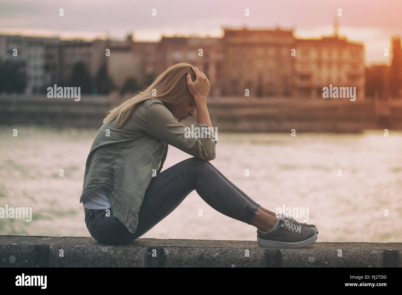 Sad pensive blonde woman sitting hi-res stock photography and images ...