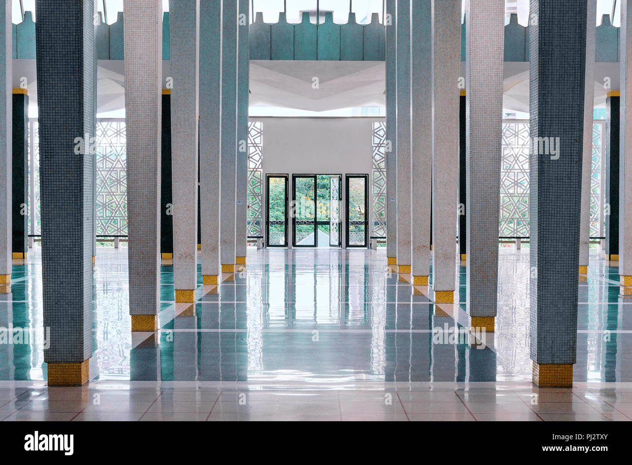 Long corridor between many columns with open doors in the end ...