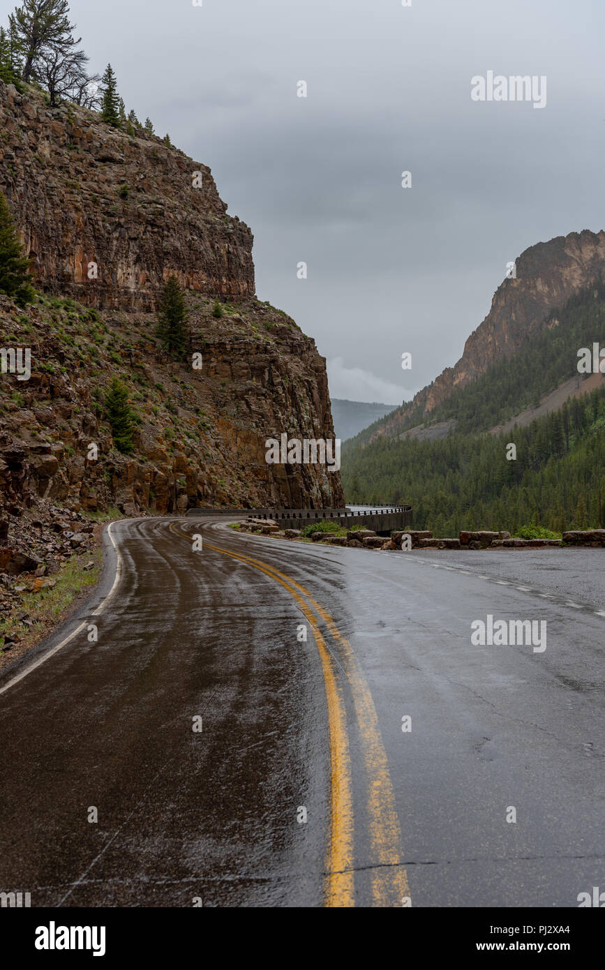 Wet Road Curves Around Rock Cliff in Canyon Stock Photo - Alamy