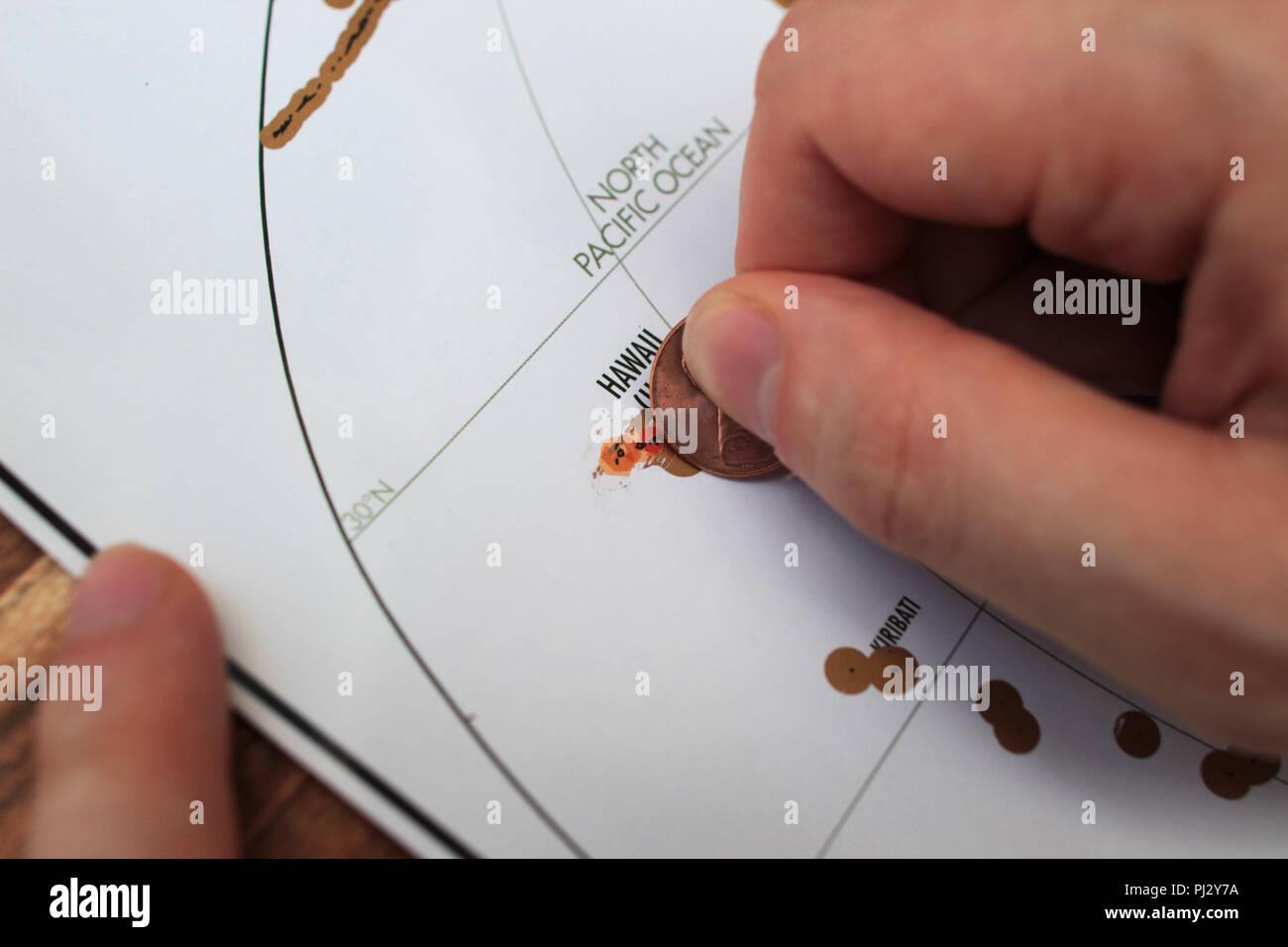 Man's hand scratching off visited places on a map. US travel. A travel ...