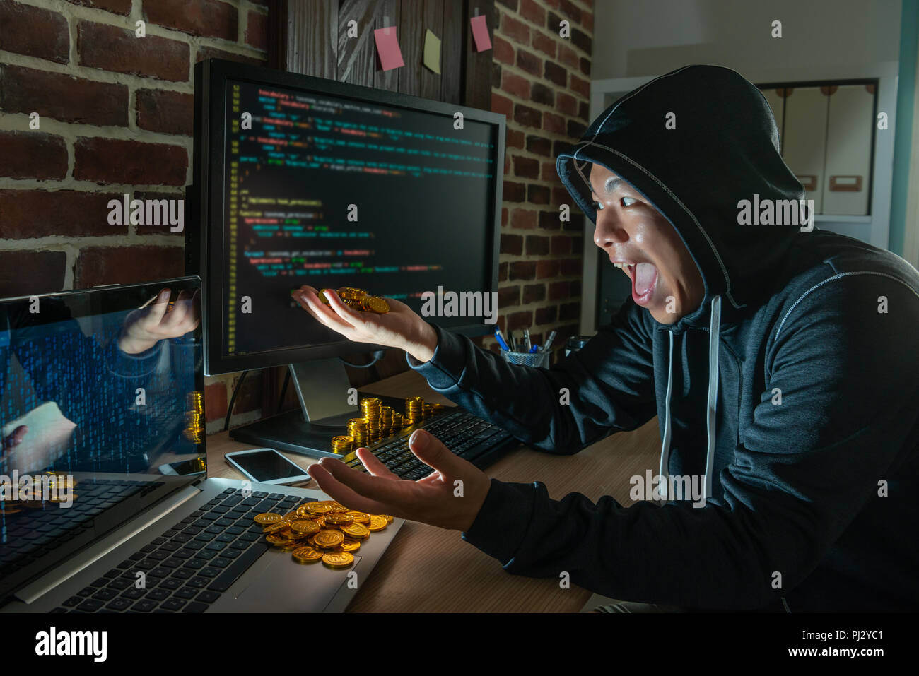 male hacker laughing happily for robbery ransom. grabbing a pile of ...