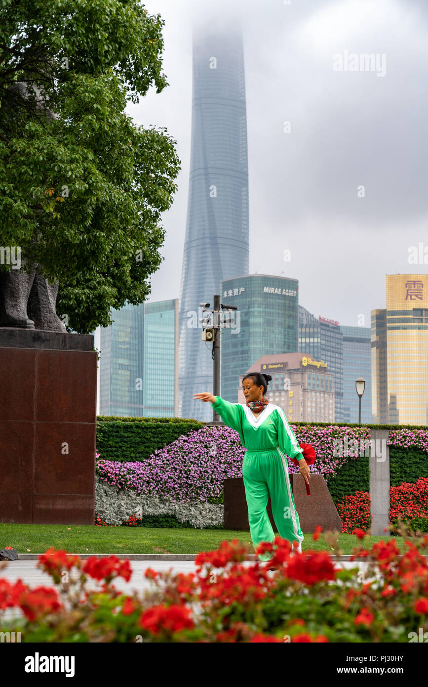 Shanghai, China - Women performs early morning exercise routine along ...