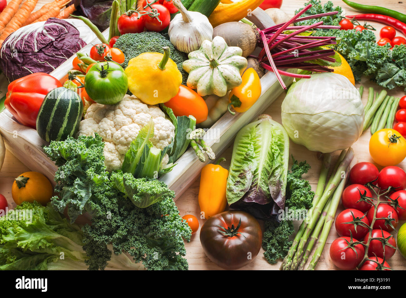 Assortment of fresh colorful organic vegetables in white tray on wooden ...