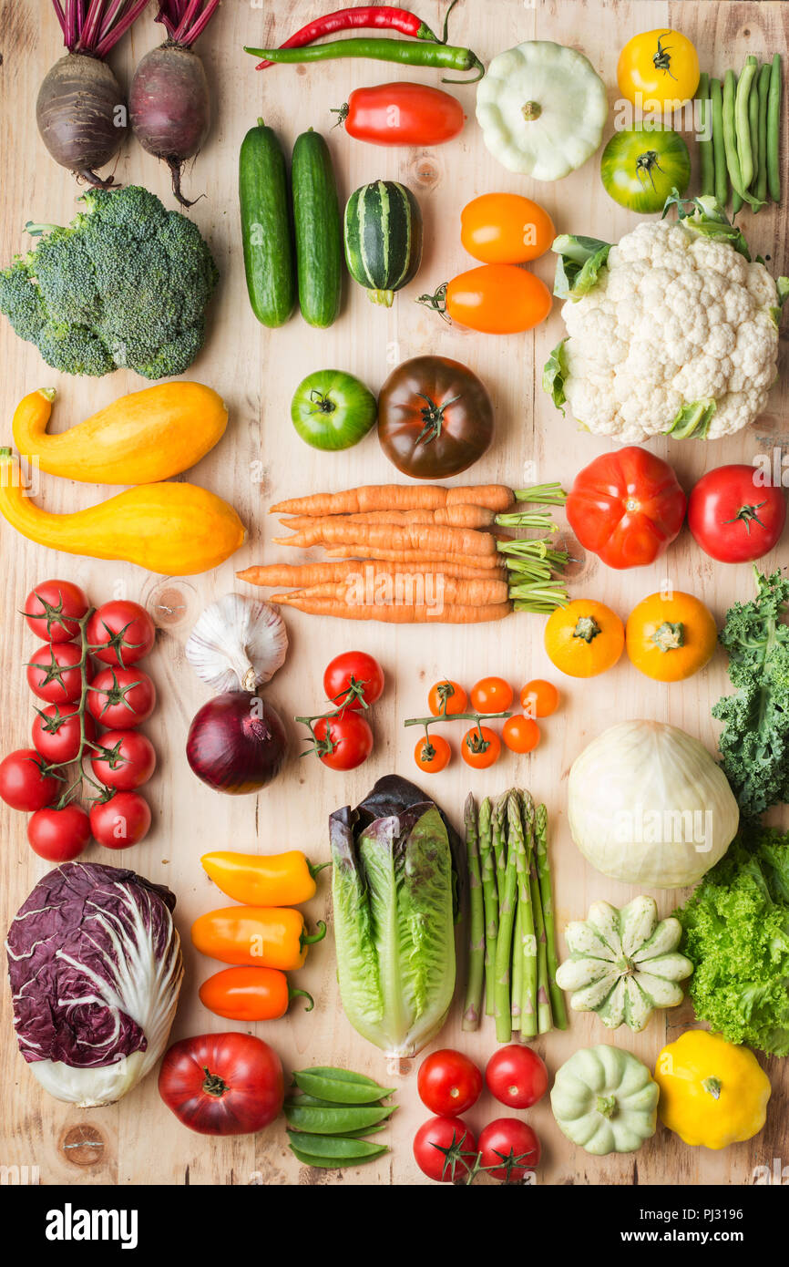 Assortment of fresh colorful organic vegetables on wooden pine table ...