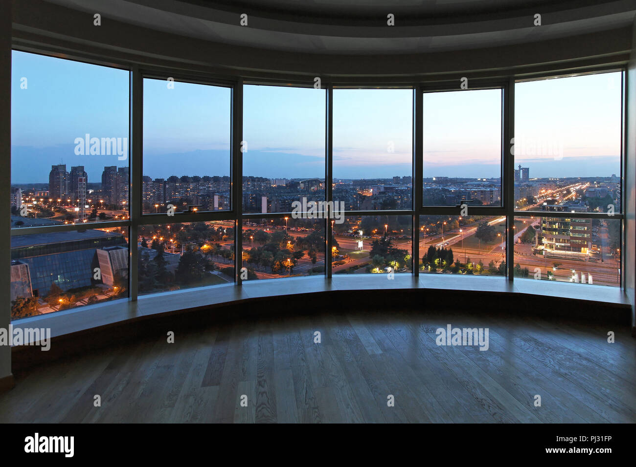 Big glass wall in oval living room with cityscape view Stock Photo - Alamy
