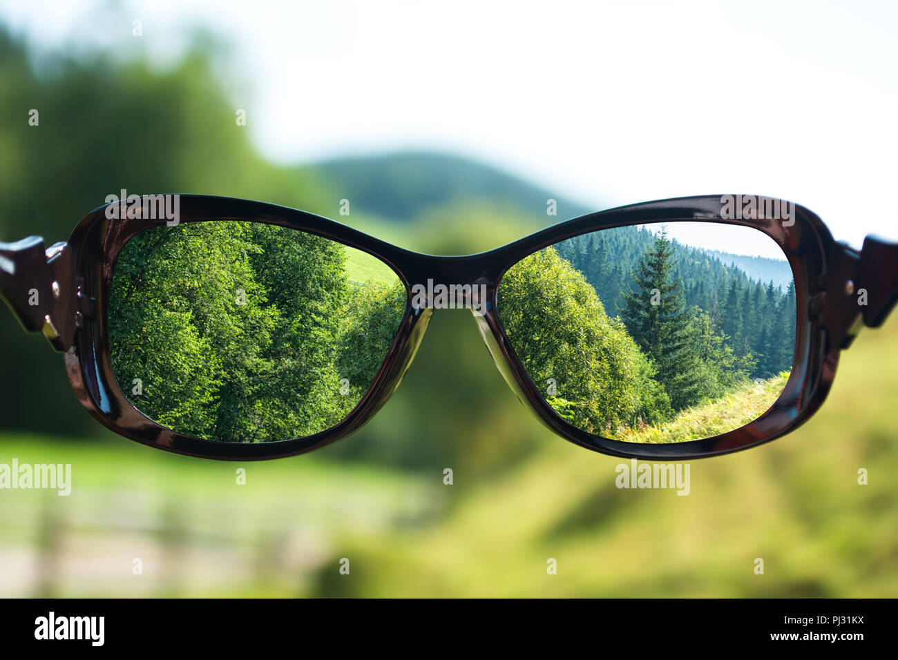 Creative concept about poor vision. Landscape focused in glasses lenses ...