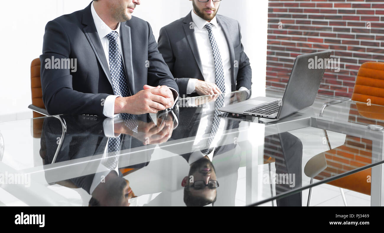 Portrait of two business people sitting at office desk Stock Photo - Alamy