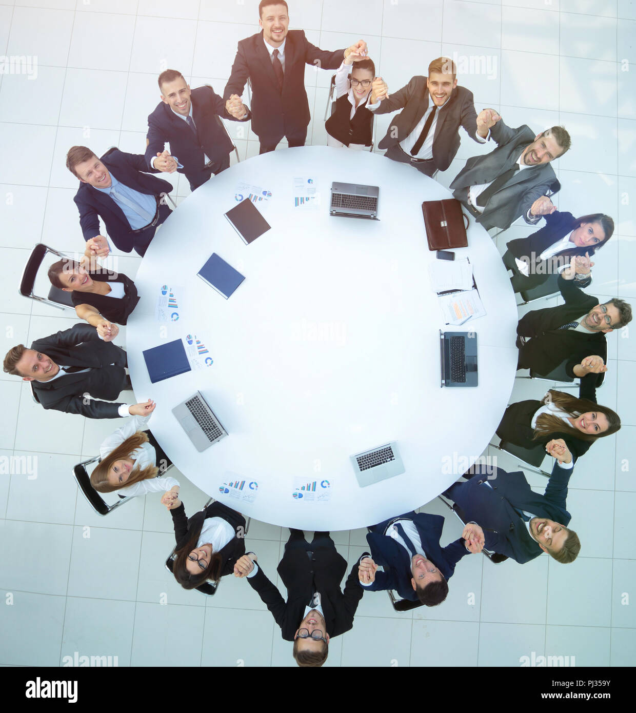 large business team sitting at the round table and raising his hands up ...