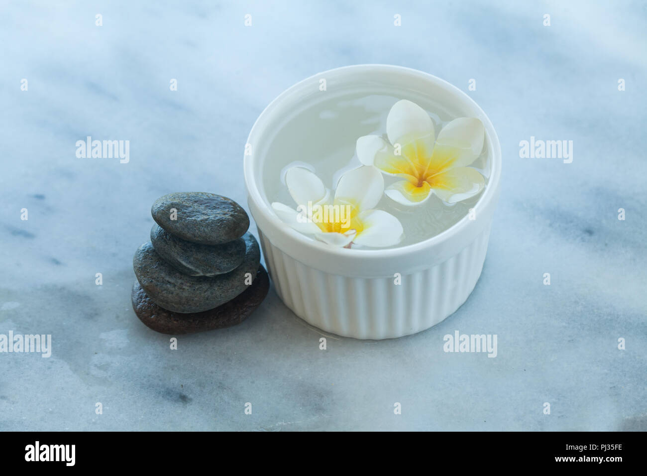 spa objects and stones in white bowl on white marble background Stock ...
